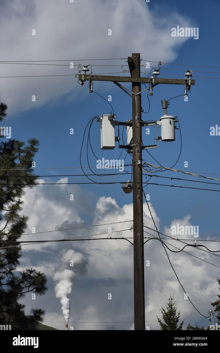 A smokestack chimney belches thick white smoke from a pulp mill in to a ...