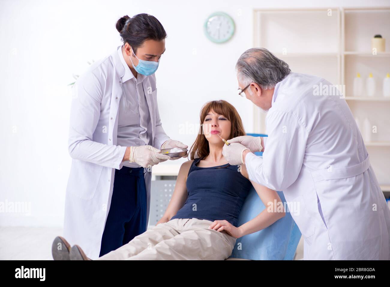 Two male doctors and young woman in surgery concept Stock Photo - Alamy