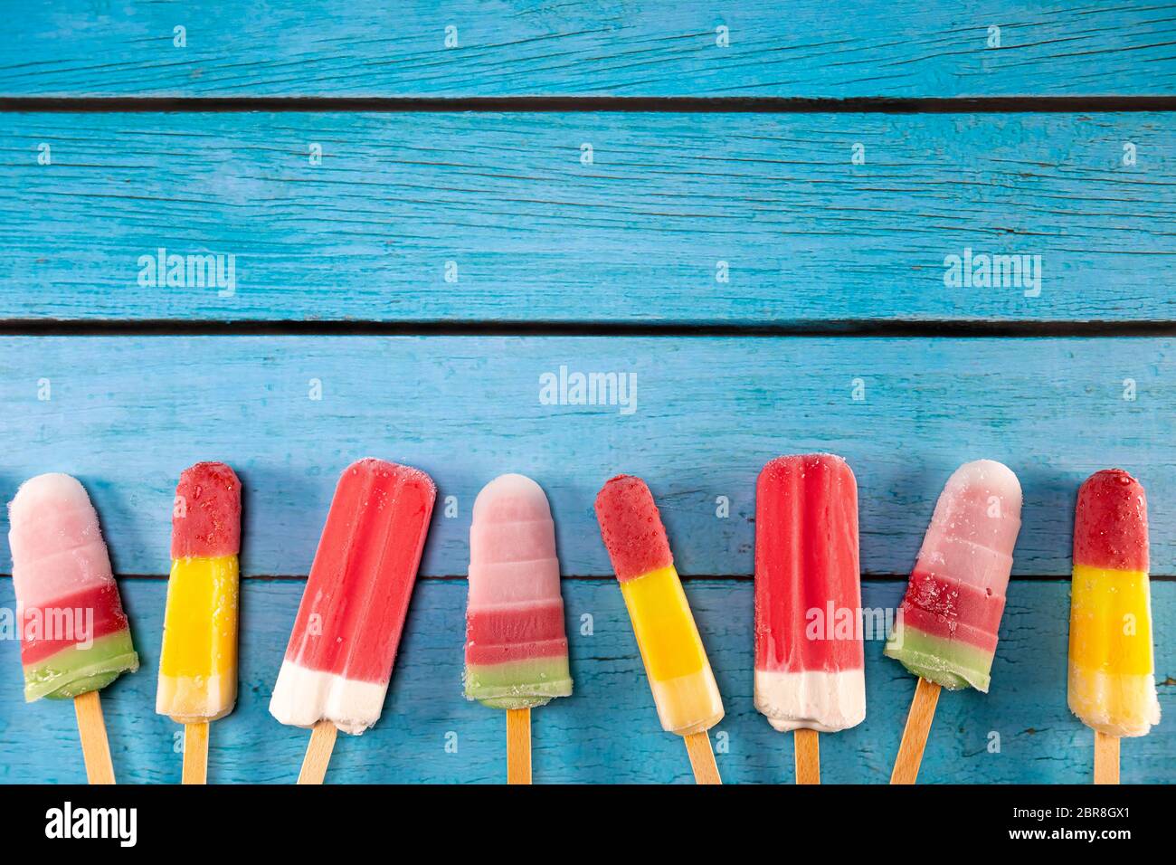 Colorful fruit ice cream stick look fresh to eat placed on a blue ...