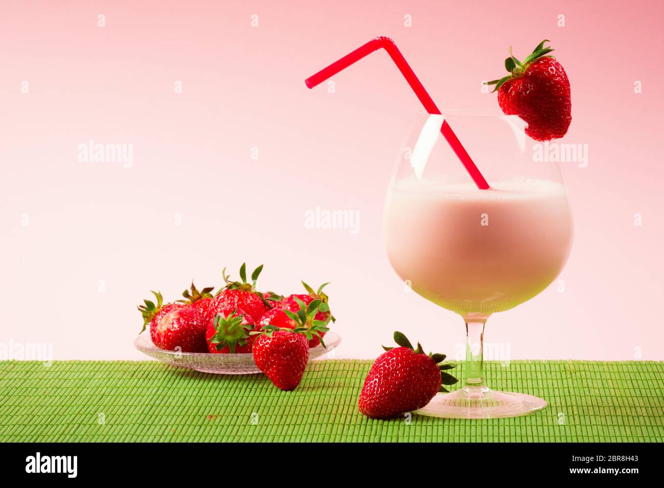 Strawberry milkshake drink with strawberries on pink background Stock ...