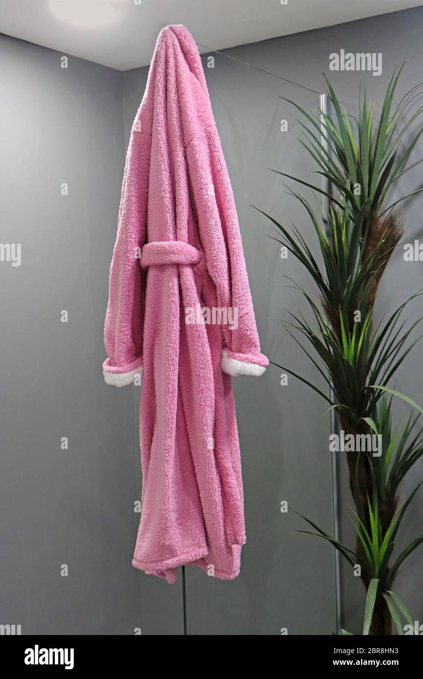 Soft pink bath robe hanging on the glass inside spa interior Stock ...