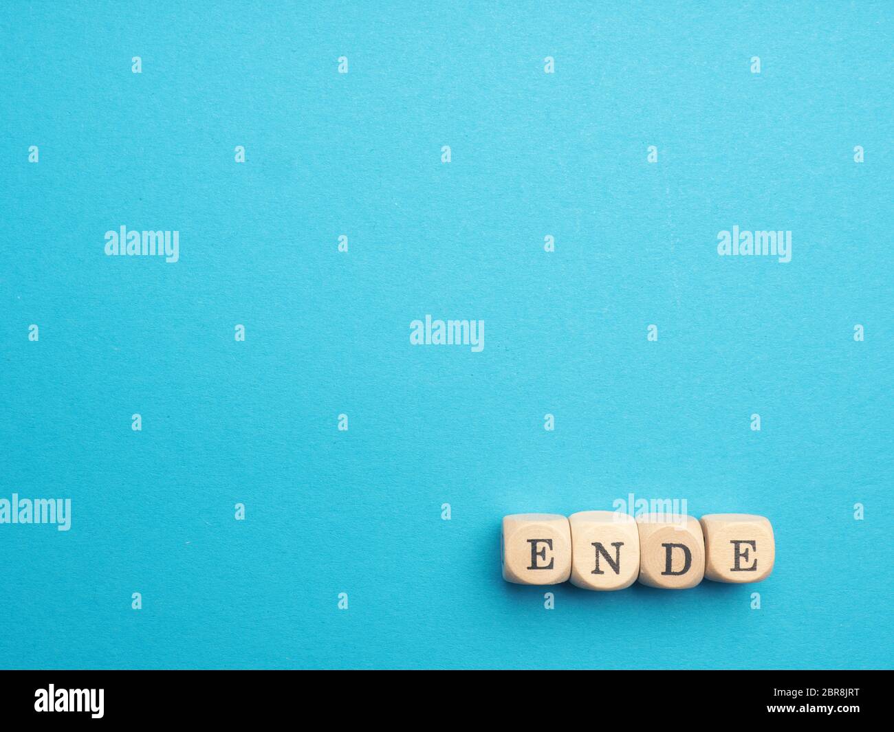 Small wooden blocks with the German word End on a blue background with ...