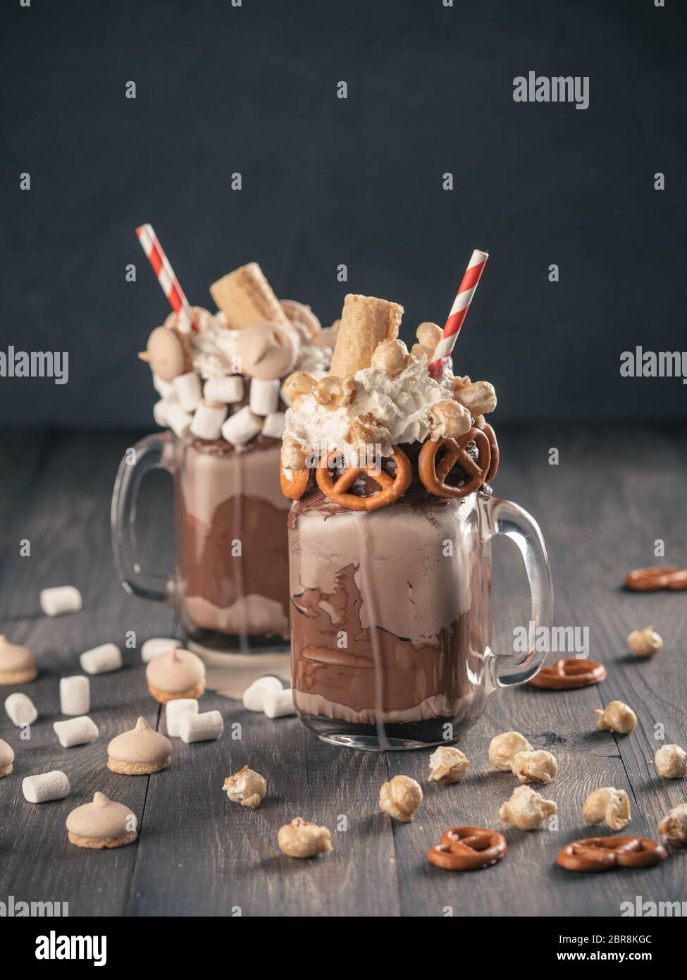 Close up view of two freakshake in mason jar on brown table. Freaked ...