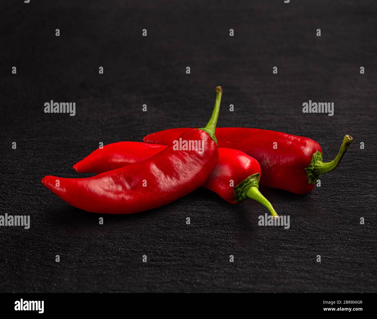 Long sweet peppers on black background Stock Photo - Alamy