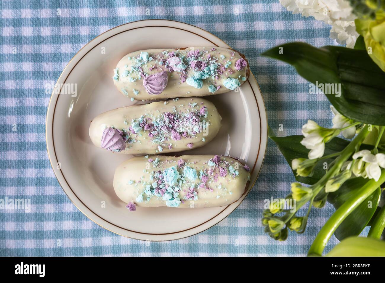 Traditional french eclairs is typically piped into an oblong shape with ...