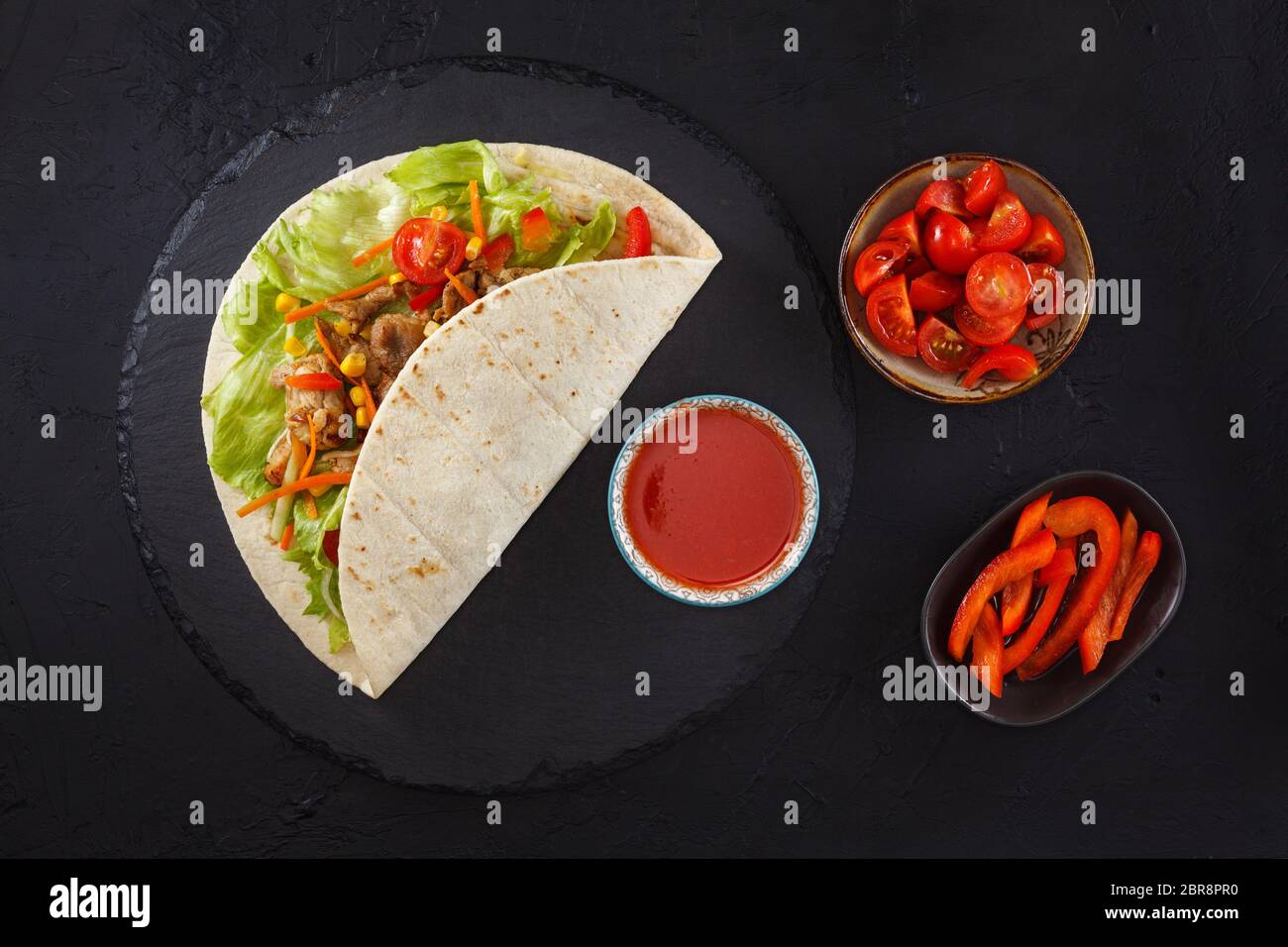 Burritos wraps with chicken and vegetables on black slate. Chicken burrito, mexican food Stock ...