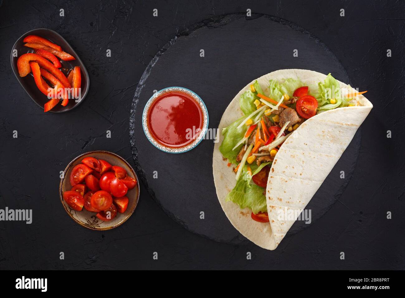 Burritos wraps with chicken and vegetables on black slate. Chicken burrito, mexican food Stock ...