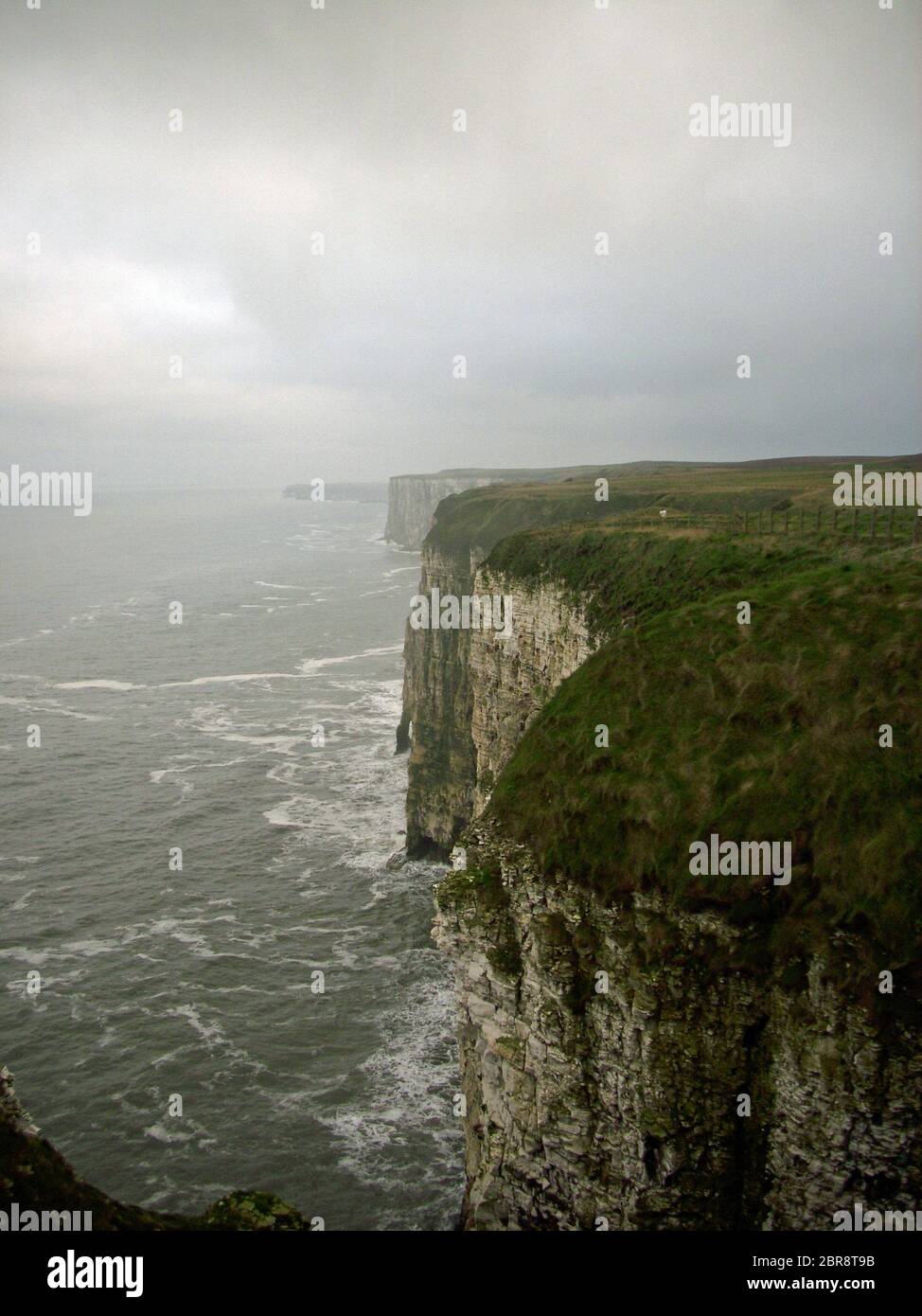 High chalk cliffs with sea and mist. Grey sky as background Stock Photo ...