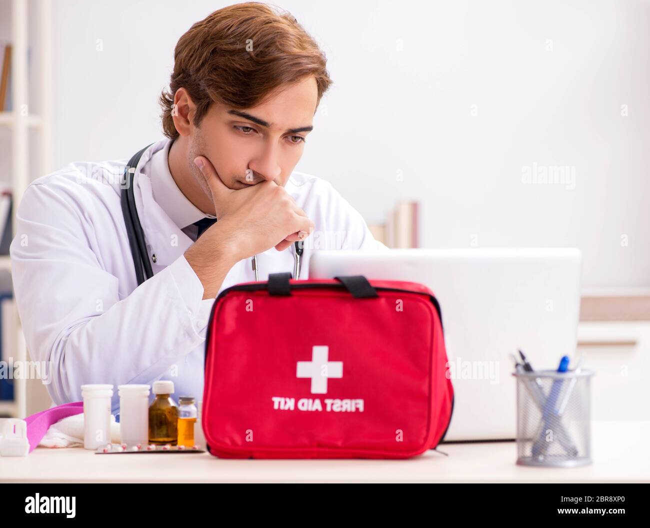 The young doctor with first aid kit in hospital Stock Photo - Alamy