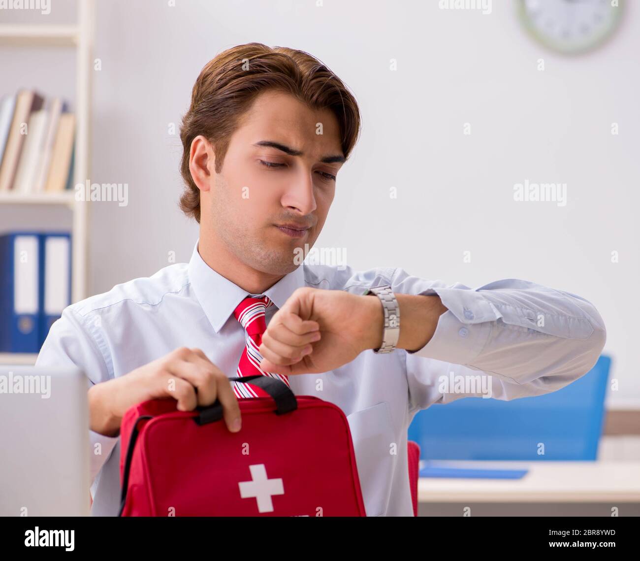 The man with first aid kit in the office Stock Photo - Alamy