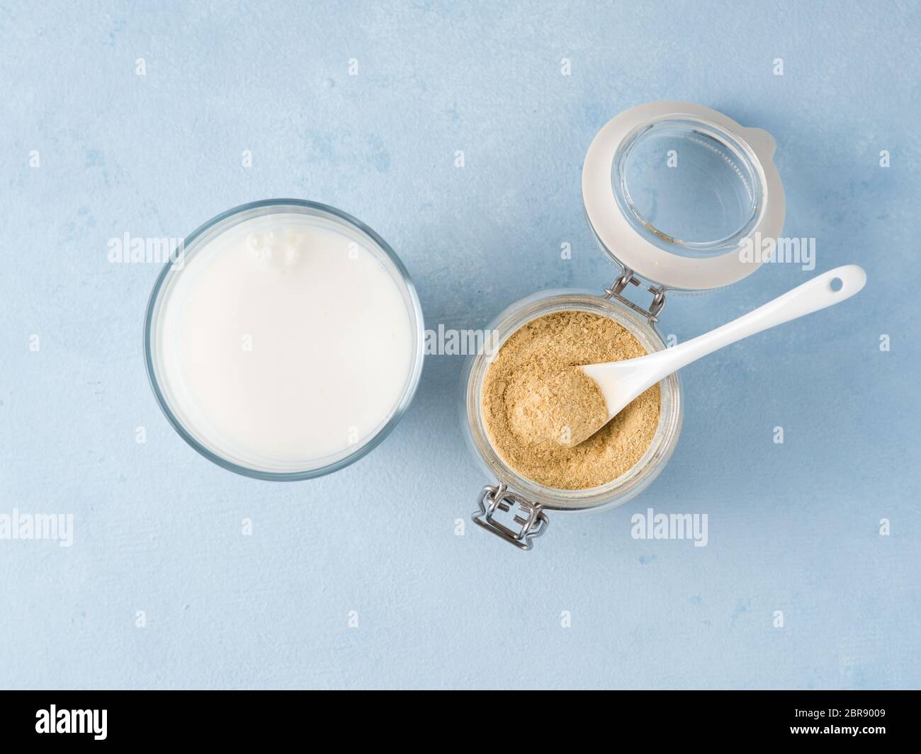 Nutritional yeast and milk. Nutritional inactive yeast in jar and glass ...