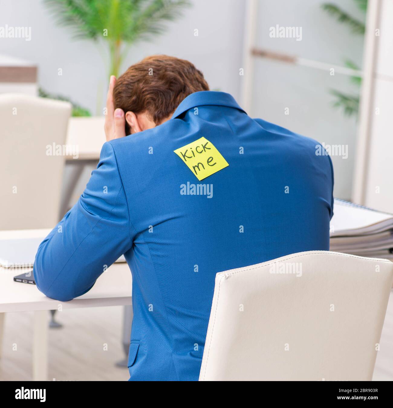The office prank with kick me message on sticky note Stock Photo - Alamy