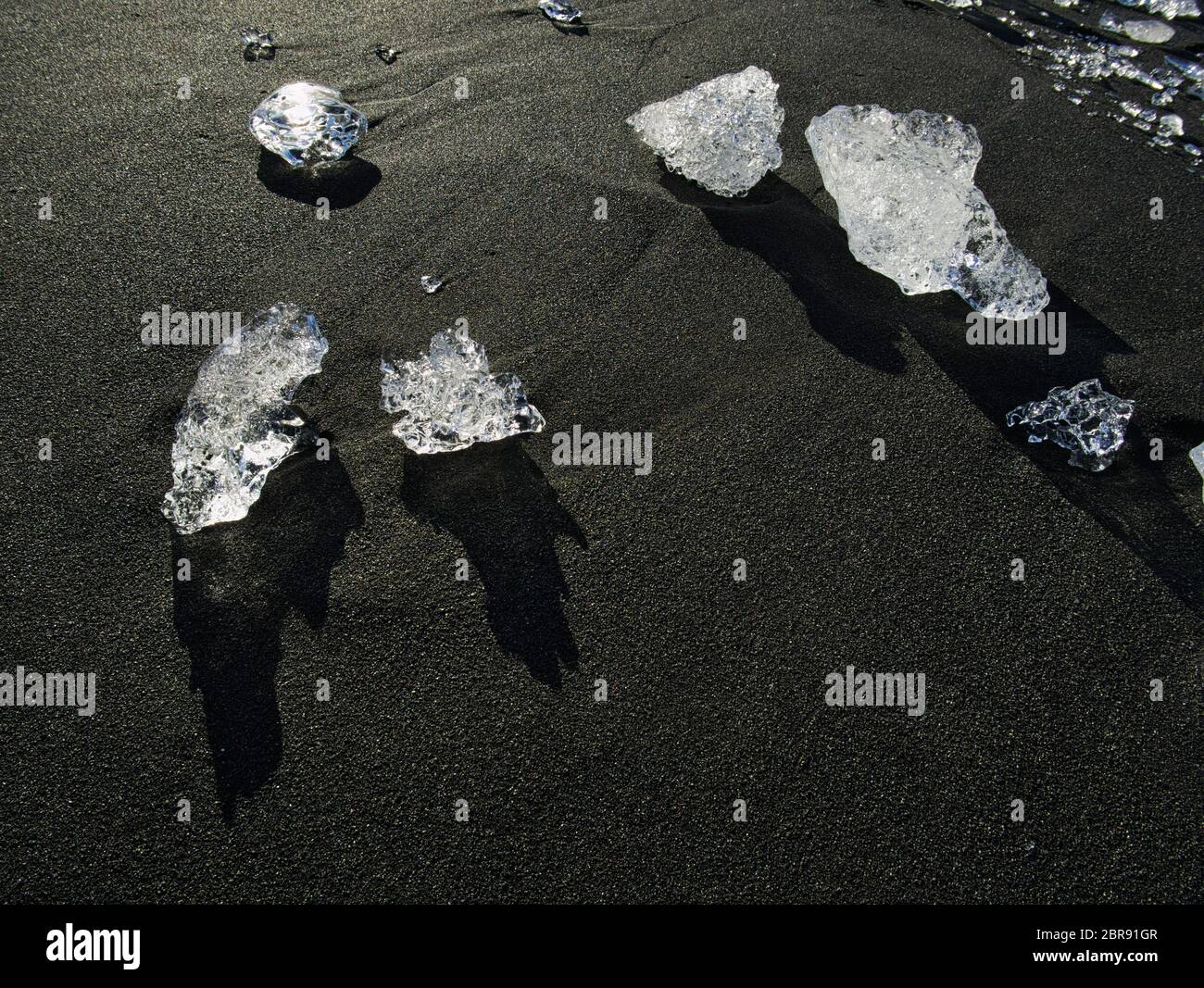 Several small ice chunks from the glacier lie in the black sand Stock ...