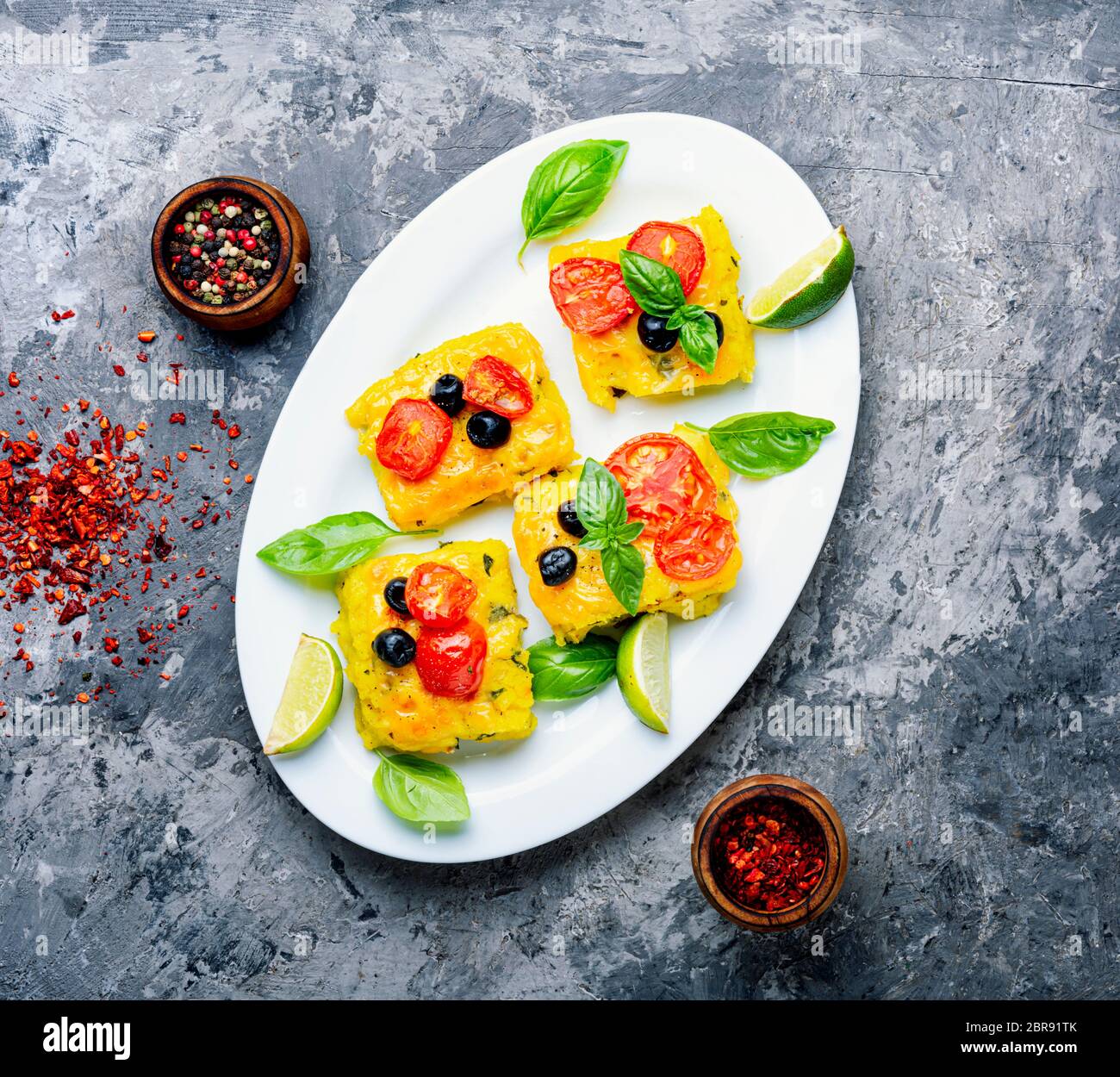 Polenta with tomatoes and cheese.Italian cuisine.Traditional polenta ...