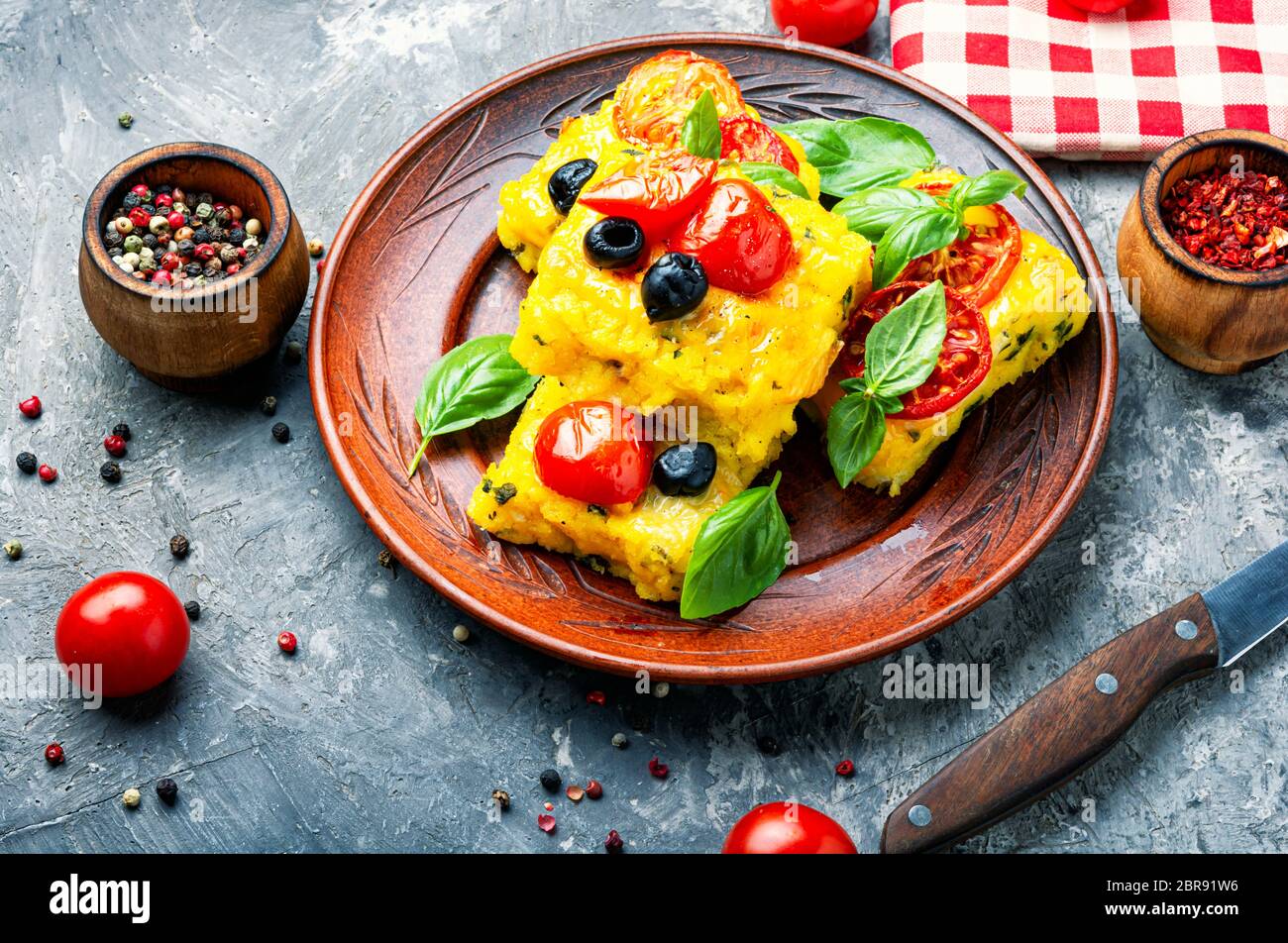 Polenta with tomatoes and cheese.Italian cuisine.Traditional polenta ...