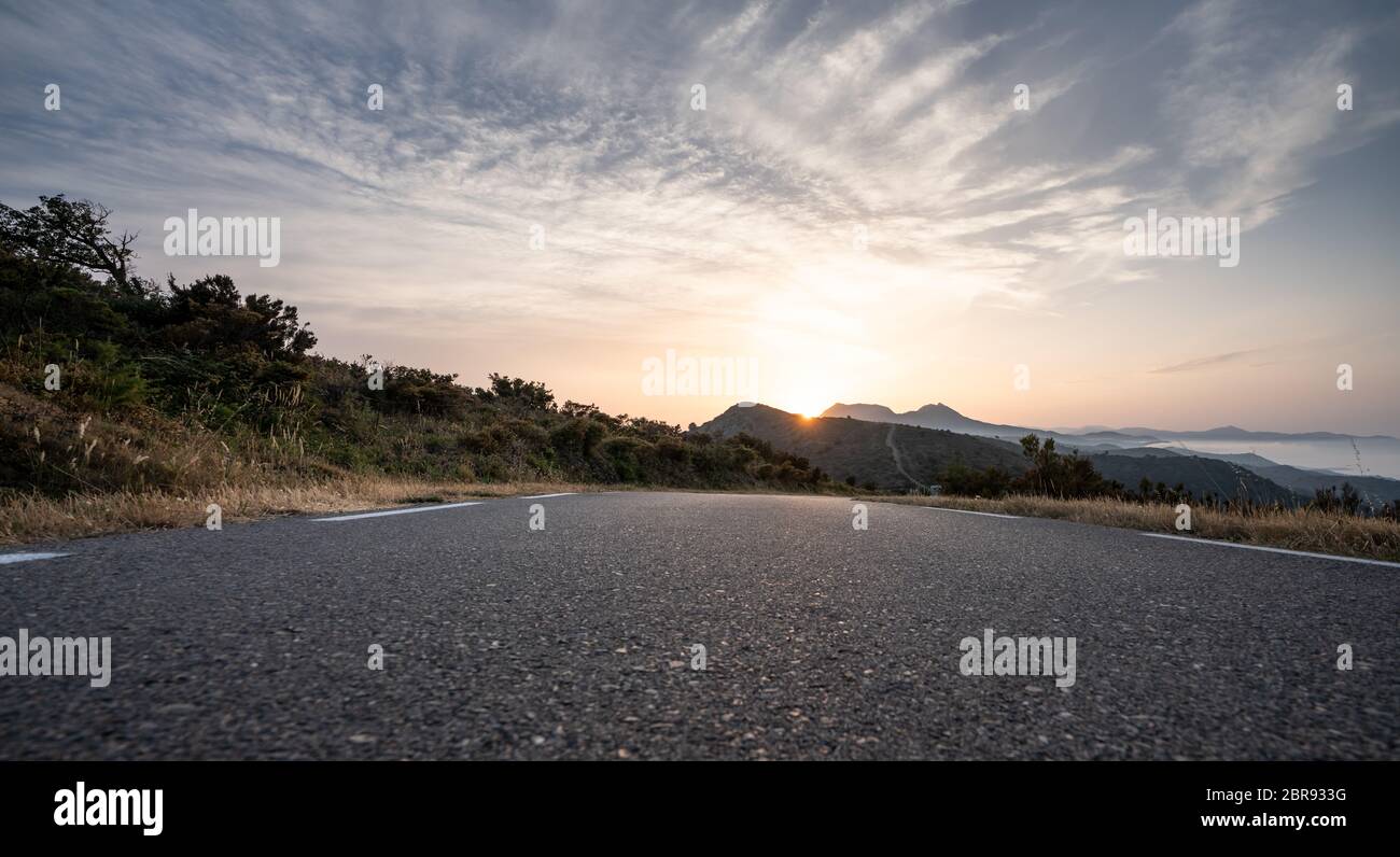 Empty long road on a sunny summer day at bright sunset Stock Photo - Alamy