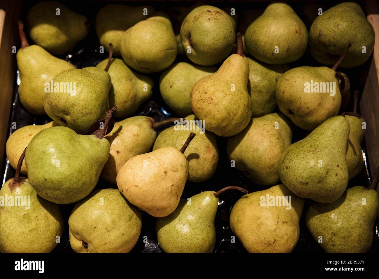 A close-up shot of an abundance of fresh Pears on display at a market ...