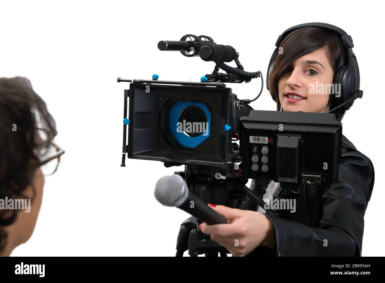 a pretty young woman journalist with microphone with video camera on ...