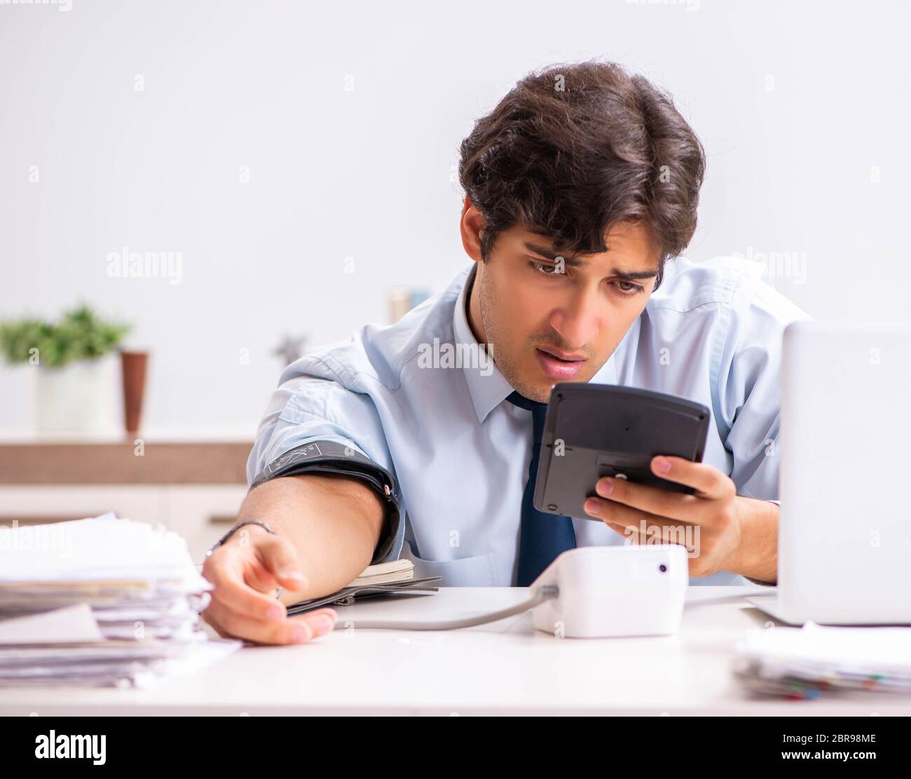 The man under stress measuring his blood pressure Stock Photo - Alamy
