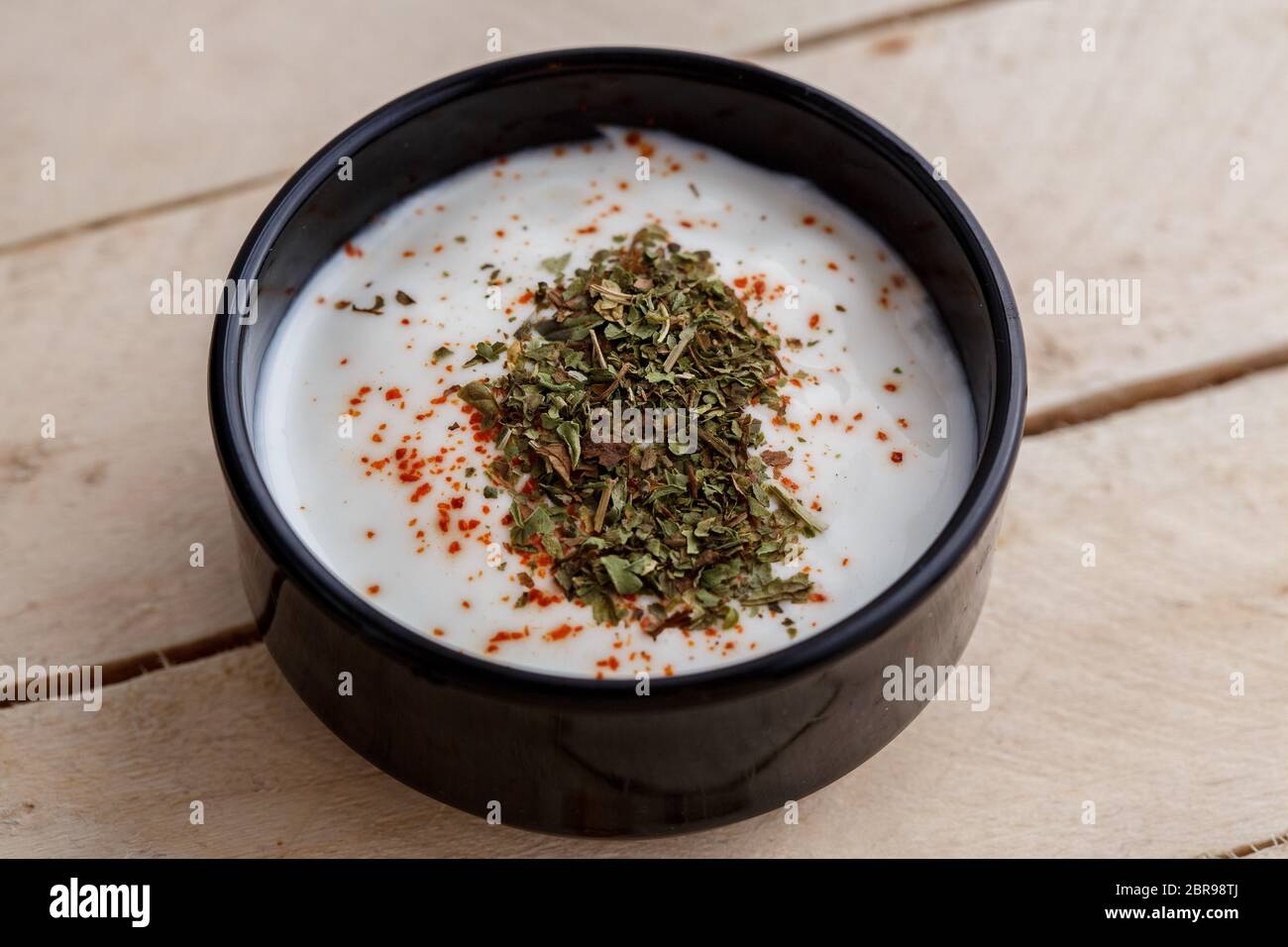 Turkish sauce of yogurt and spices in black saucer Stock Photo - Alamy