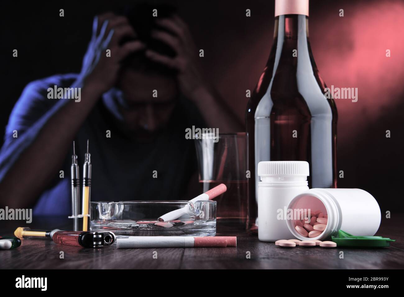 Addictive substances and the figure of a addicted man Stock Photo - Alamy