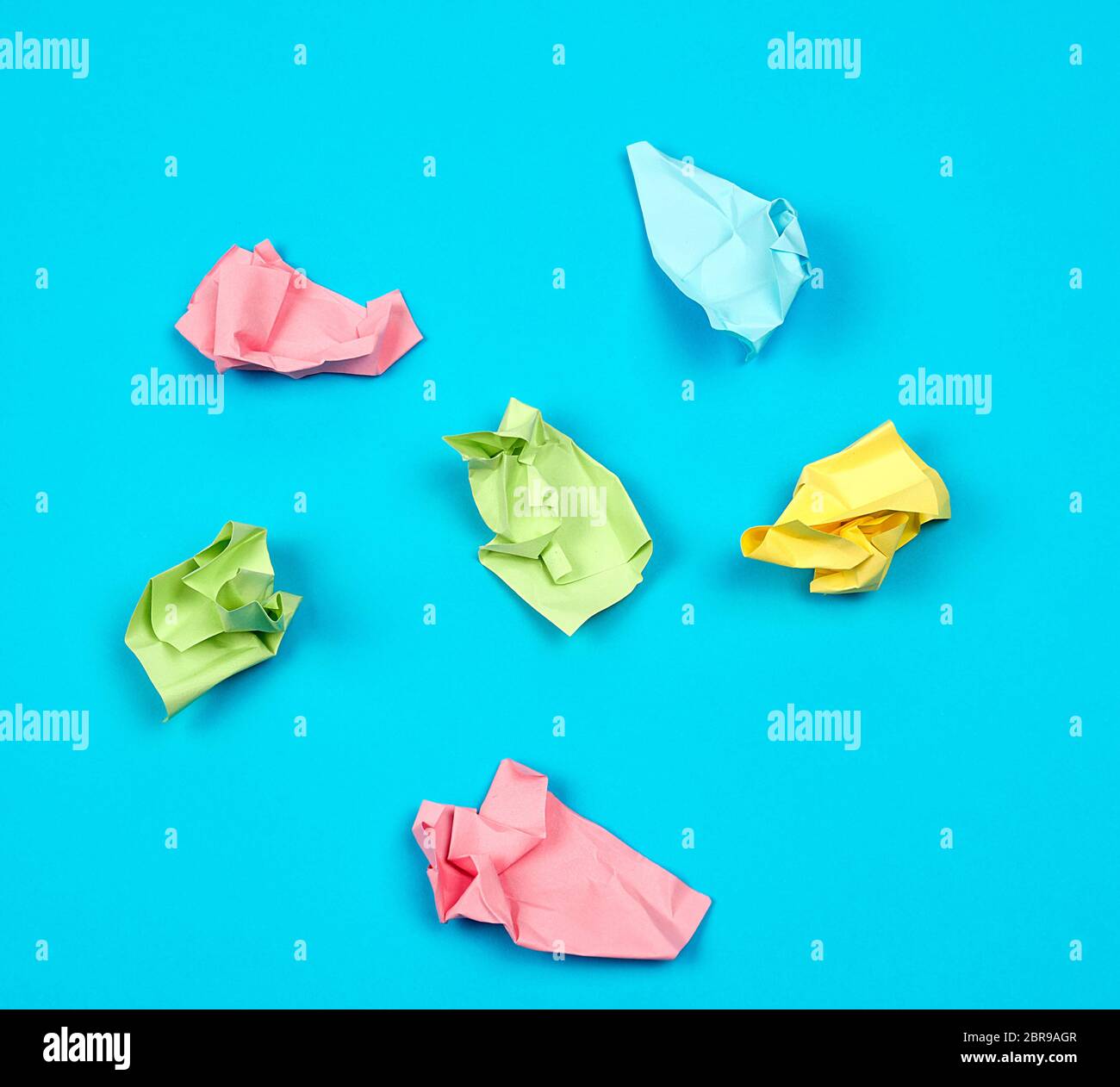 crumpled bright multi-colored paper on a blue background, abstract ...