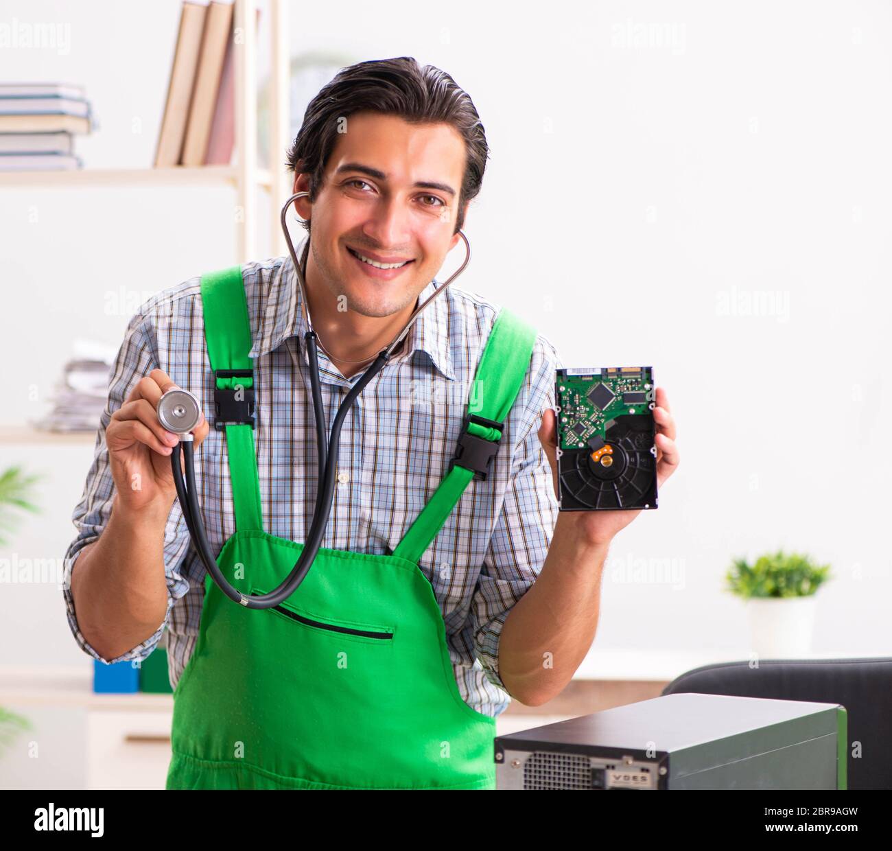 The young engineer repairing broken computer at the office Stock Photo ...