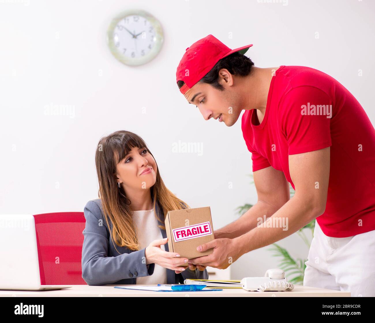 The courier delivering parcel to the office Stock Photo - Alamy