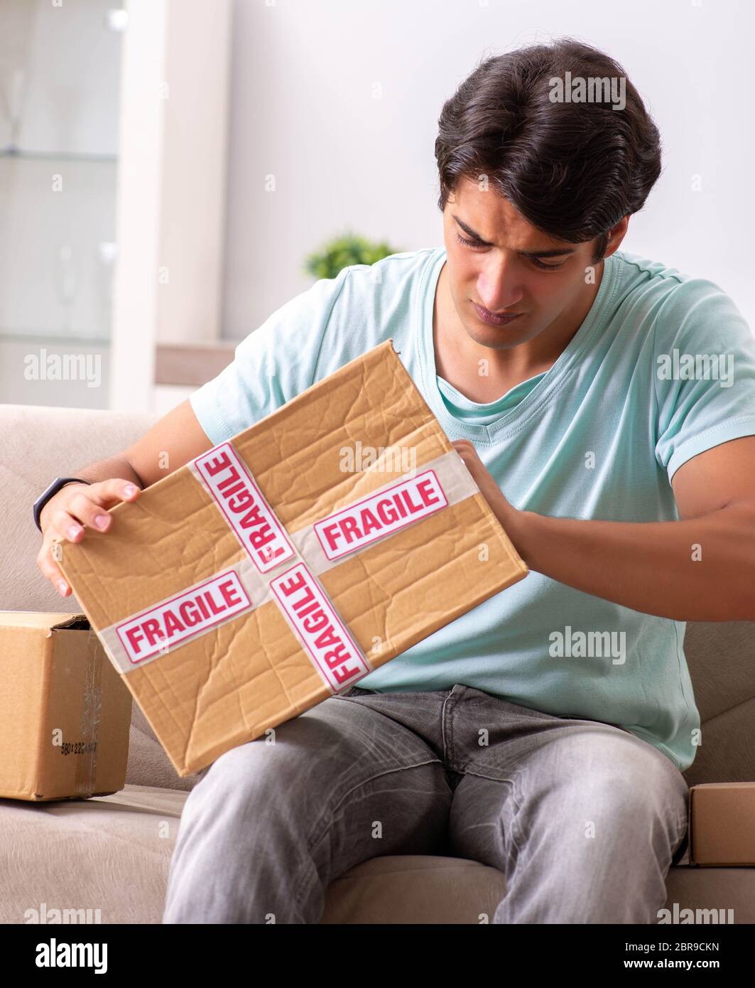 The man opening fragile parcel ordered from internet Stock Photo - Alamy