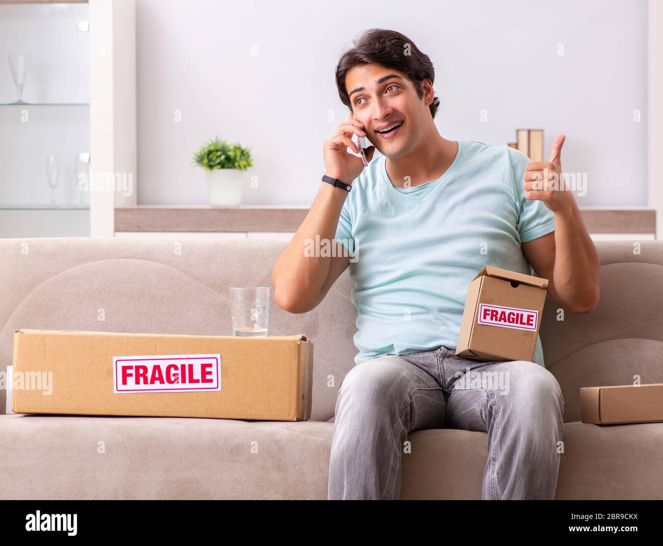The man opening fragile parcel ordered from internet Stock Photo - Alamy