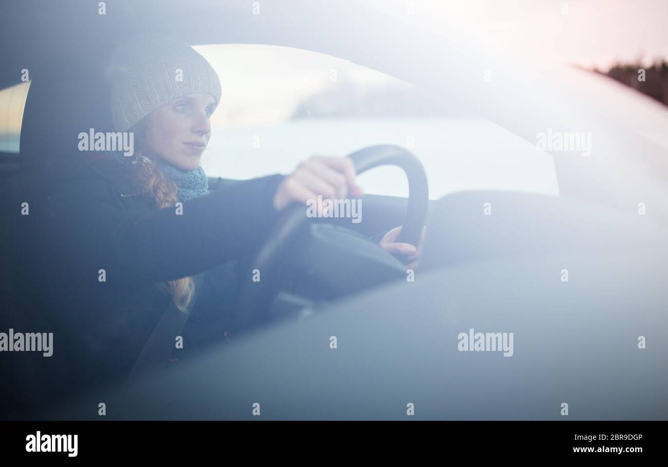 Woman driving a car - female driver at a wheel of a modern car, looking ...