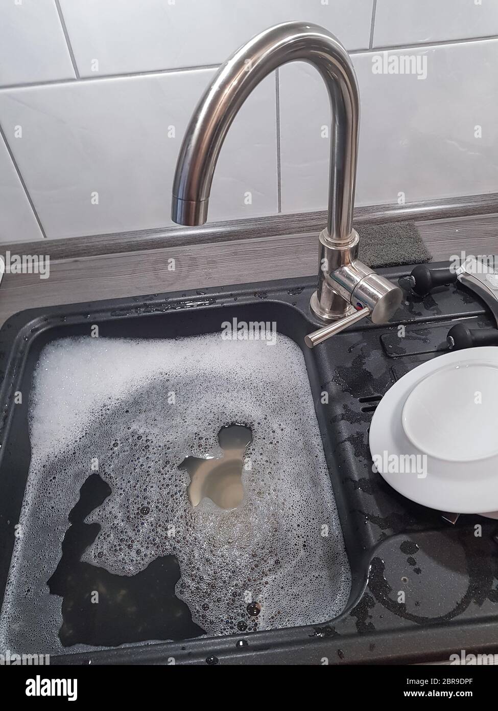 Wash and dry kitchen utensils on the sink by hand Stock Photo - Alamy