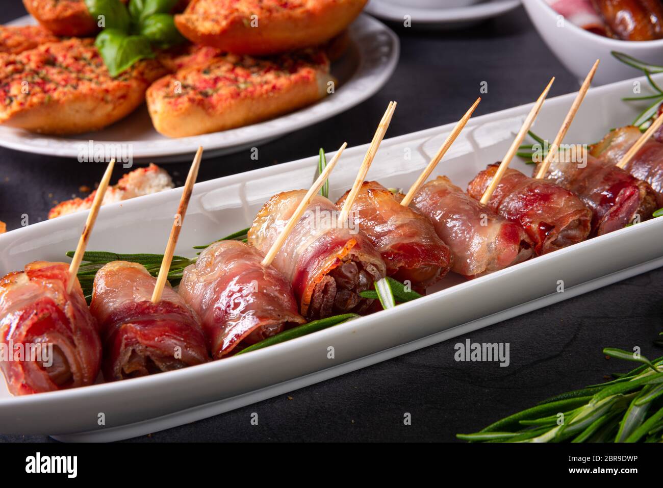 dates wrapped in bacon and delicious tapas Stock Photo - Alamy