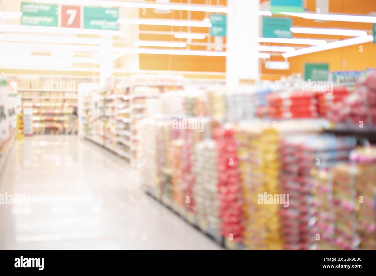 Abstract blurred supermarket aisle with rice bag of shelves and many ...