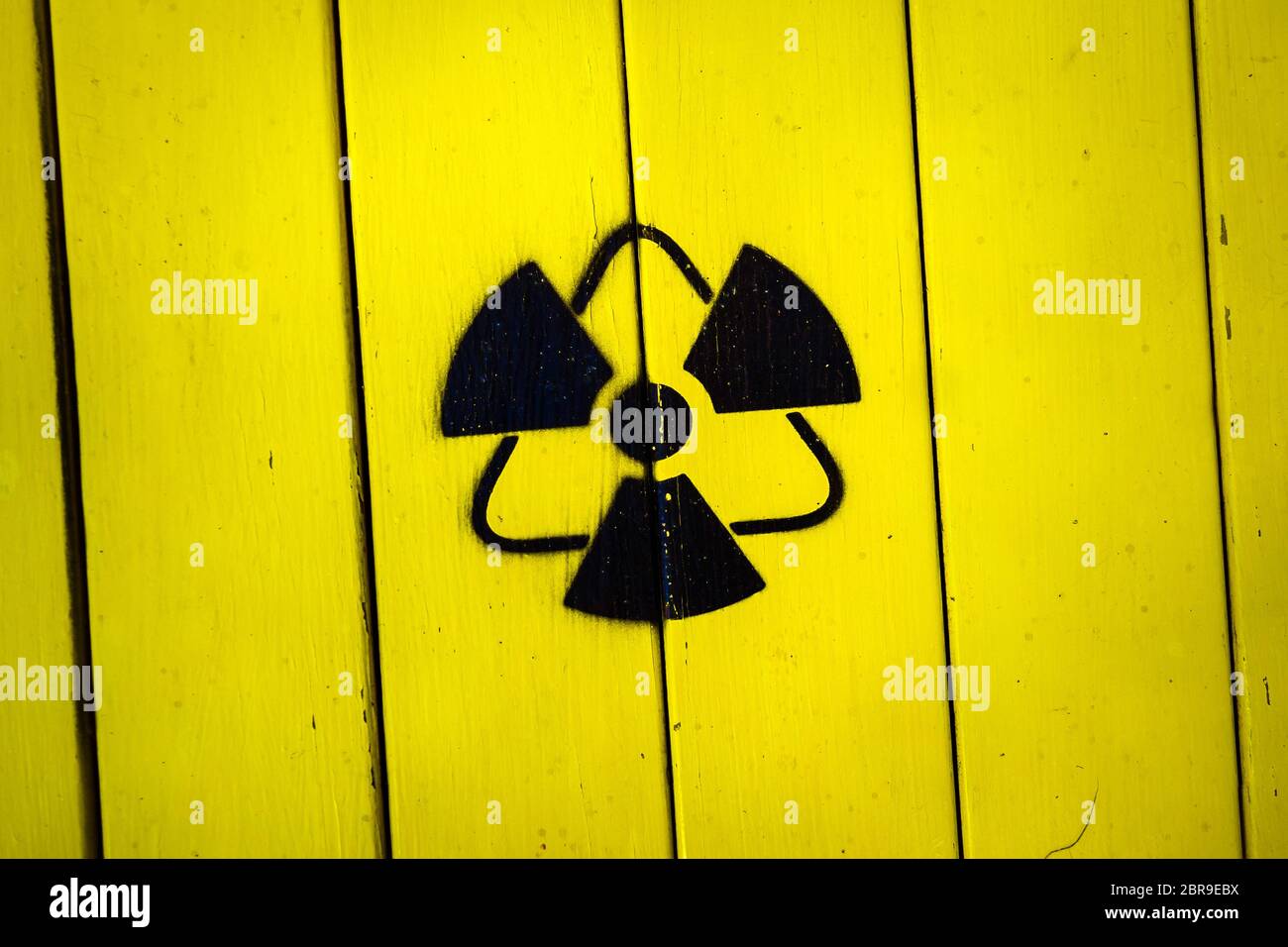 Radioactivity sign, close-up. Sign of radiation on a yellow wooden ...