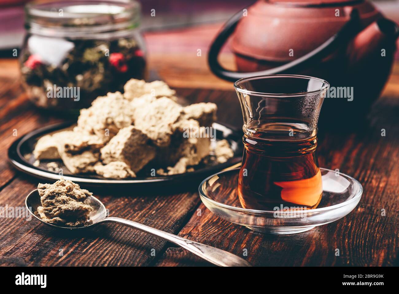 Black tea in armudu glass and spoonful of sunflower halva Stock Photo ...