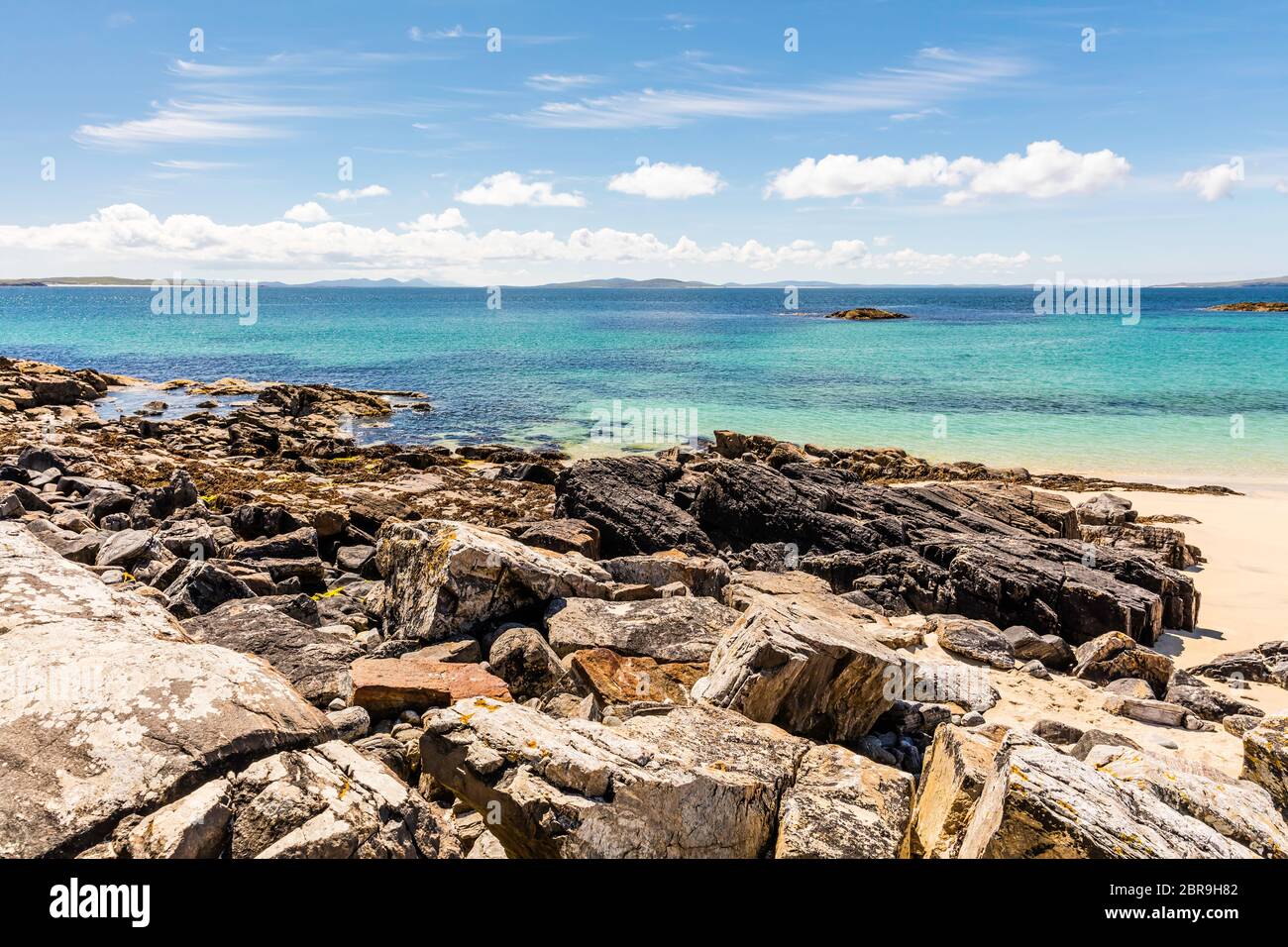 Boulders with adjacent sandy beach in front of turquoise sea Stock ...