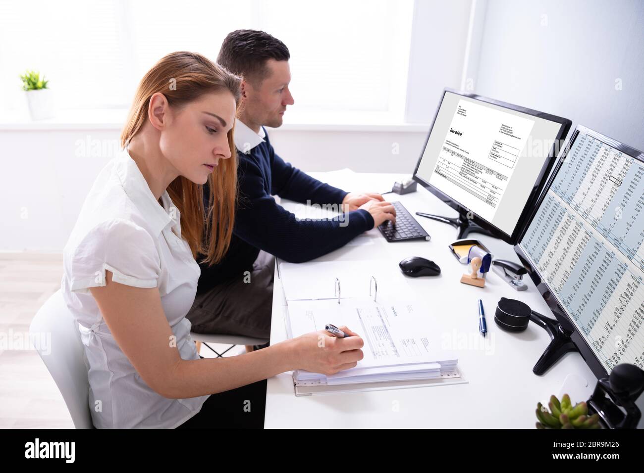 Male And Female Auditors Working On Computer With Invoice At Workplace ...