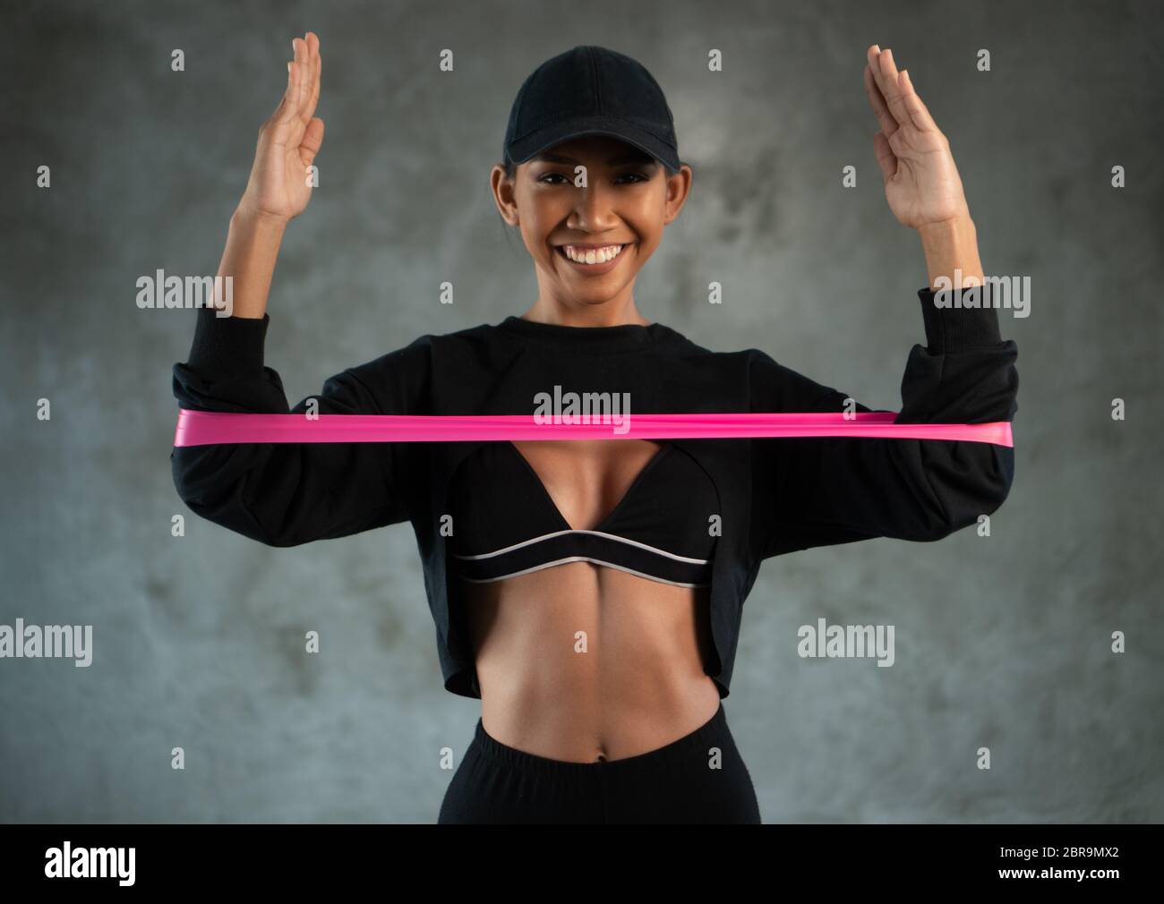 Happy healthy smiling woman working out with resistance band at the gym ...