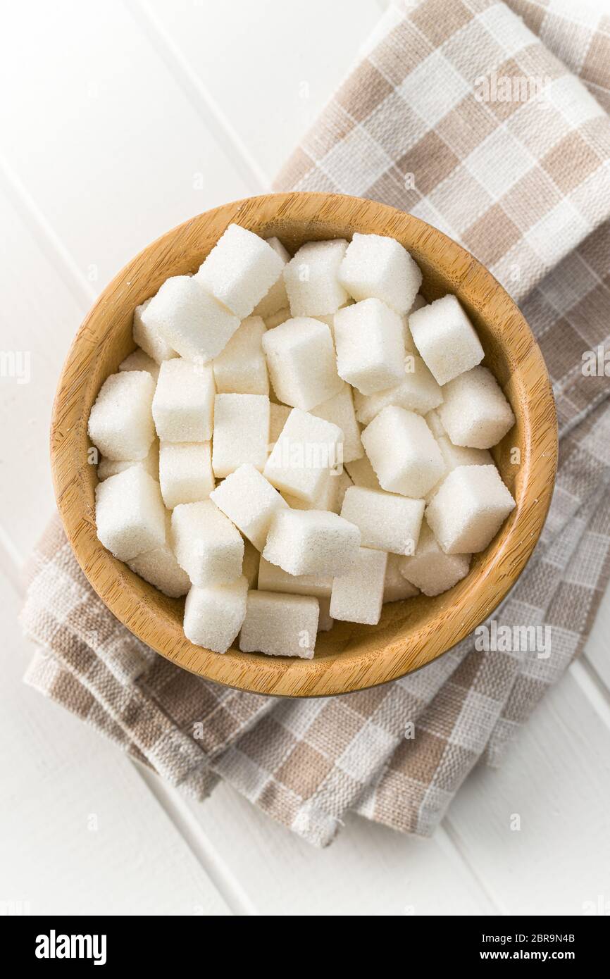Sweet sugar cubes in wooden bowl. Top view Stock Photo - Alamy
