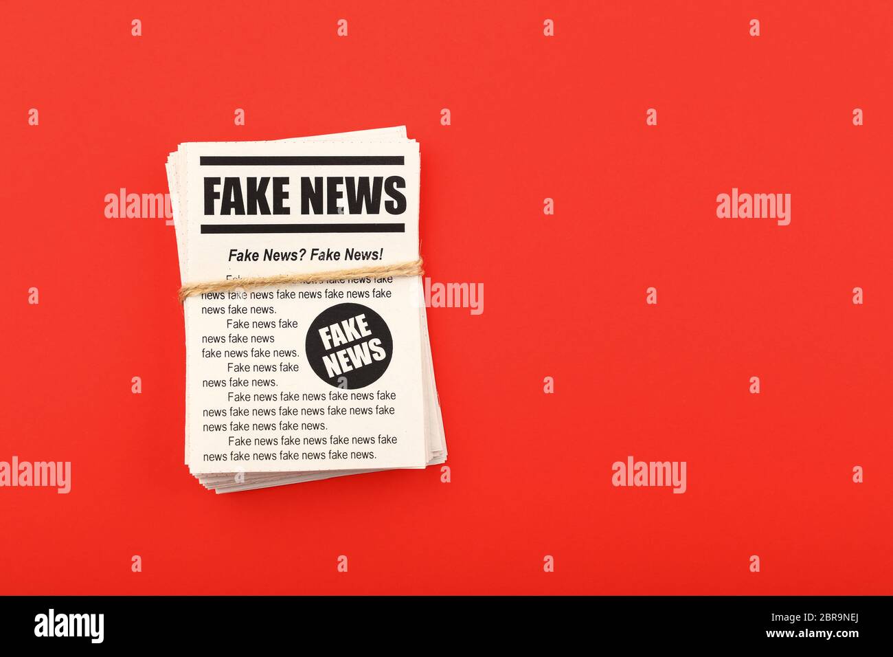 Close up stack of FAKE NEWS newspapers over red paper background with ...