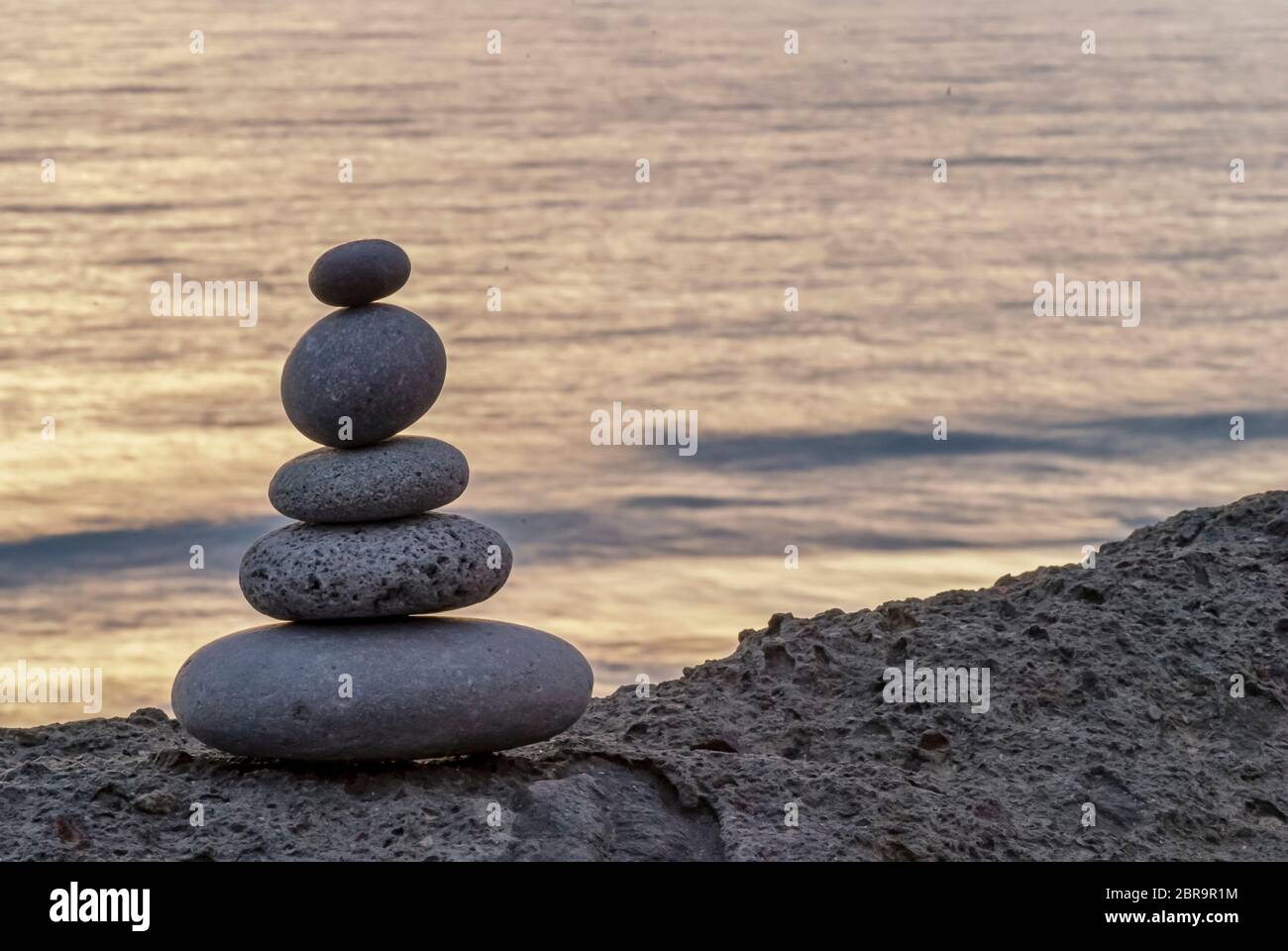 A stack of balanced pebble at the beach with the Atlantic Ocean in the ...