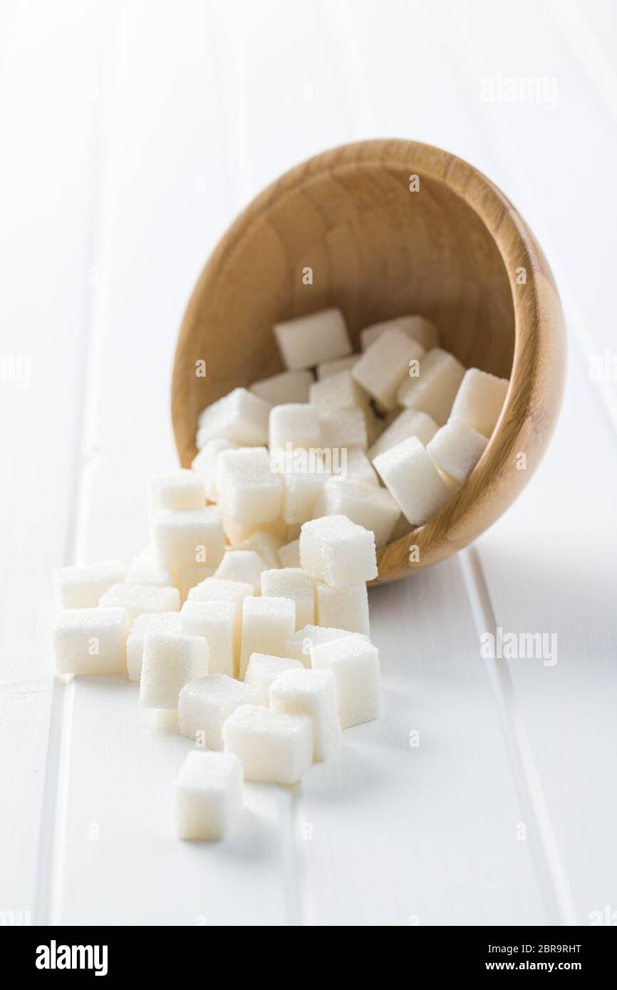 Sweet white sugar cubes in wooden bowl Stock Photo - Alamy