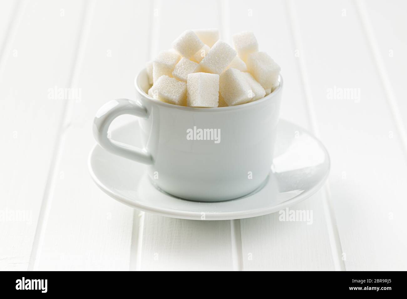 Sweet white sugar cubes in coffee mug Stock Photo - Alamy
