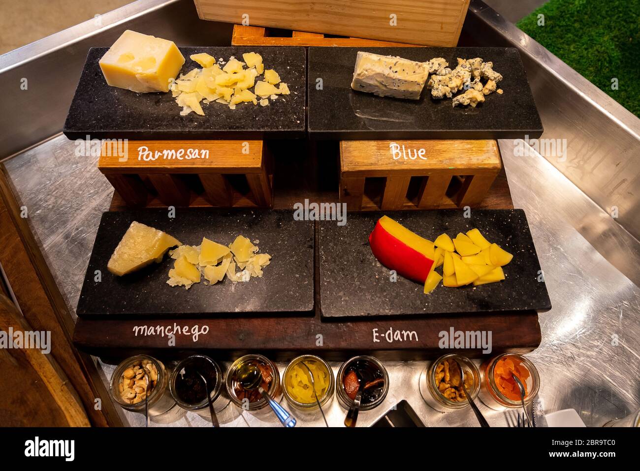 Variety of cheese on black stone plate in buffet line Stock Photo - Alamy