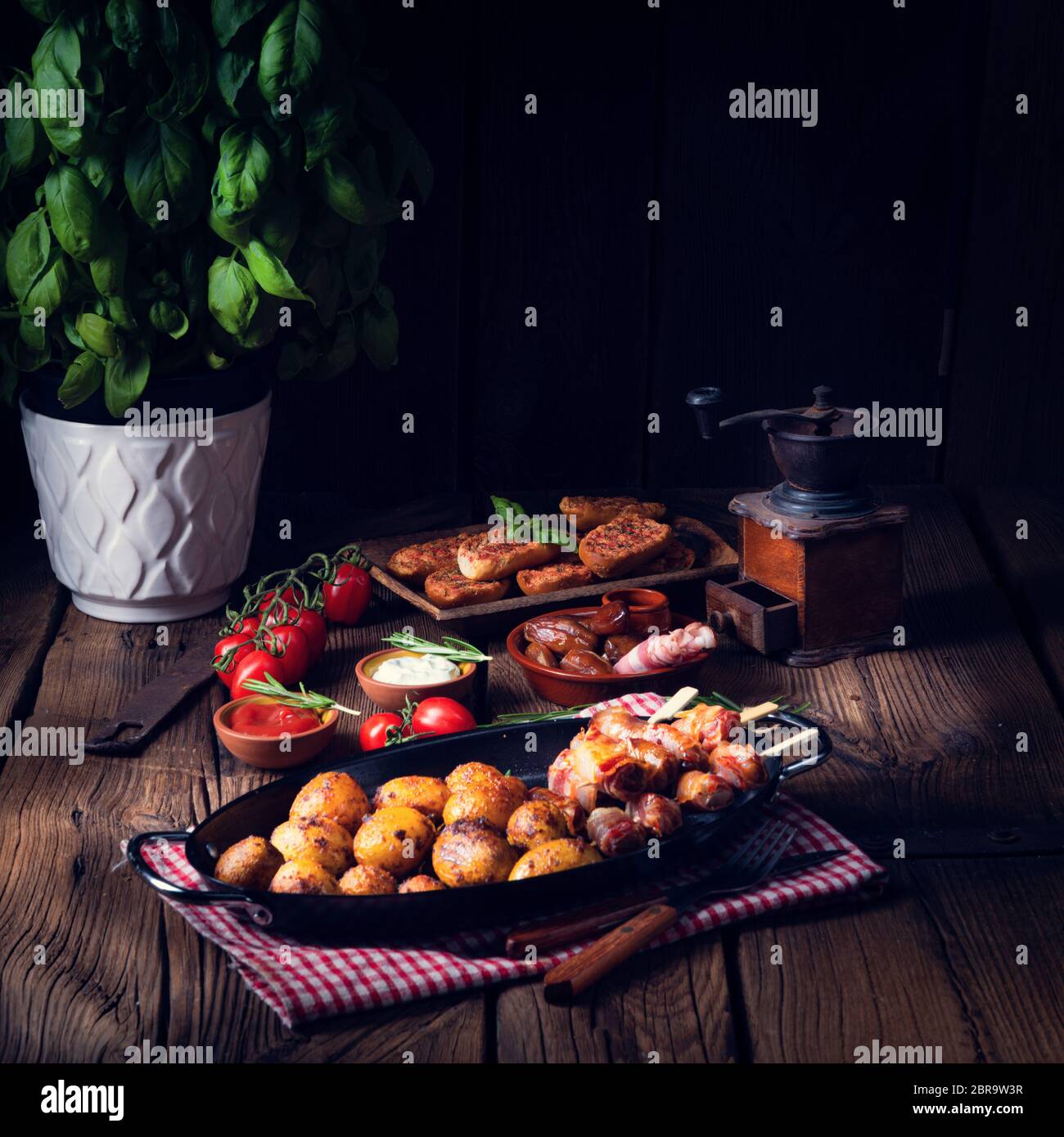 Rustic dates wrapped in bacon and young roasted potato Stock Photo - Alamy