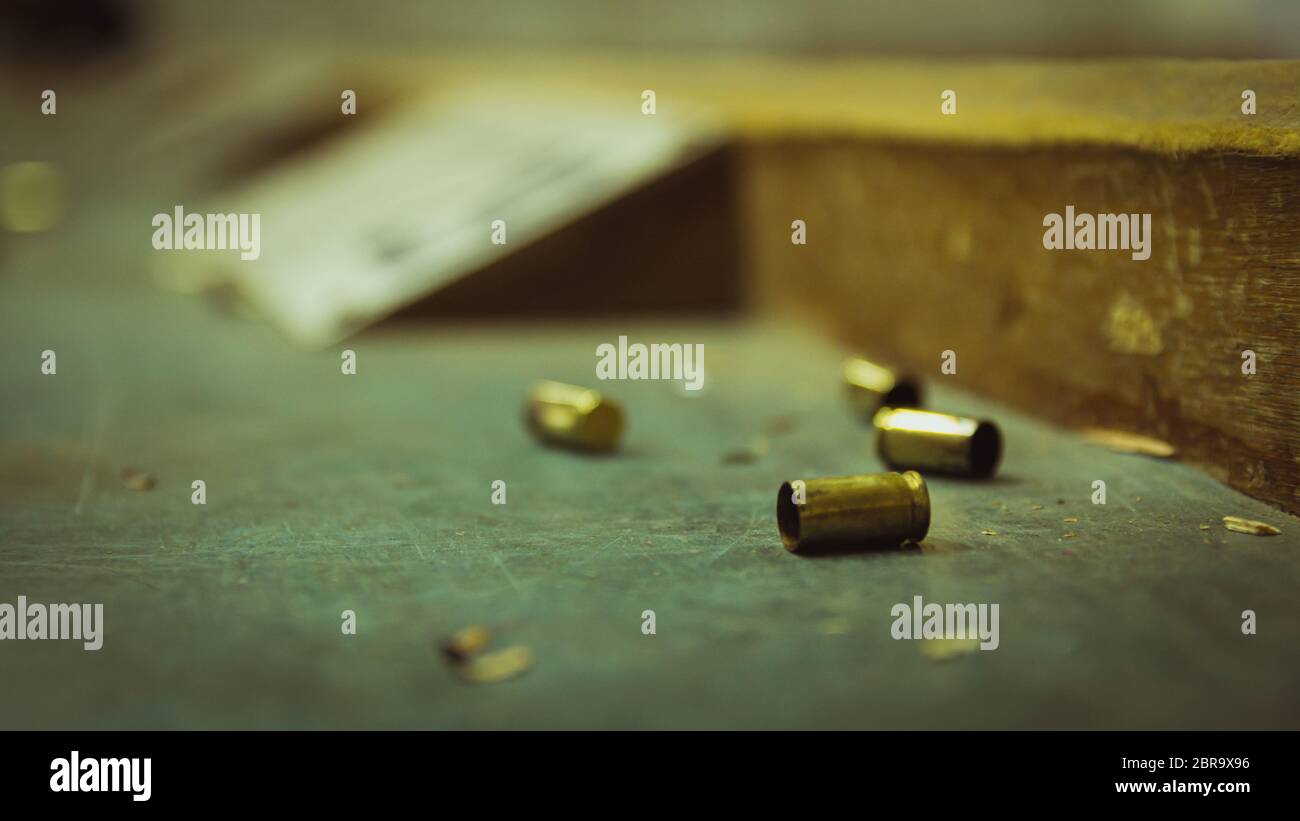 Empty pistol bullet shells on wooden table in a shooting range. Extreme ...