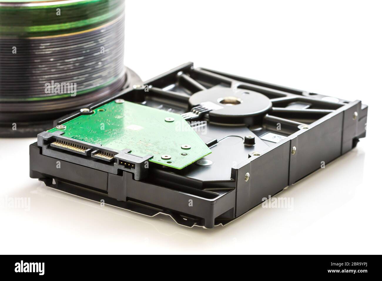 Hard disk drive (HDD) with circuit board and compact discs on white ...