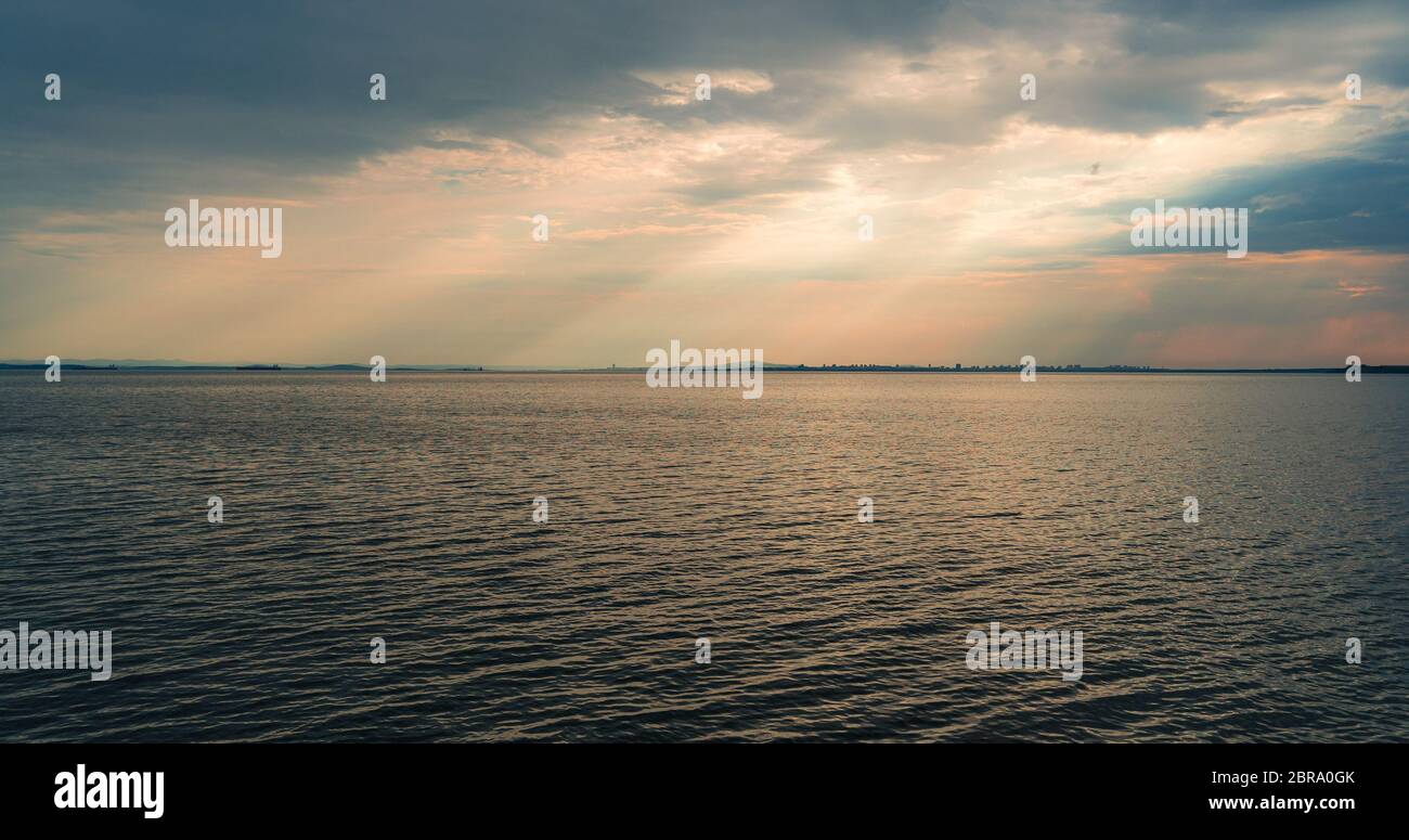 Seascape. Evening overcast sky and the rays of the sun Stock Photo - Alamy
