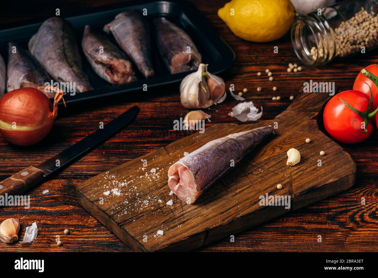 Hake carcasses on cutting board with spices and vegetables Stock Photo ...